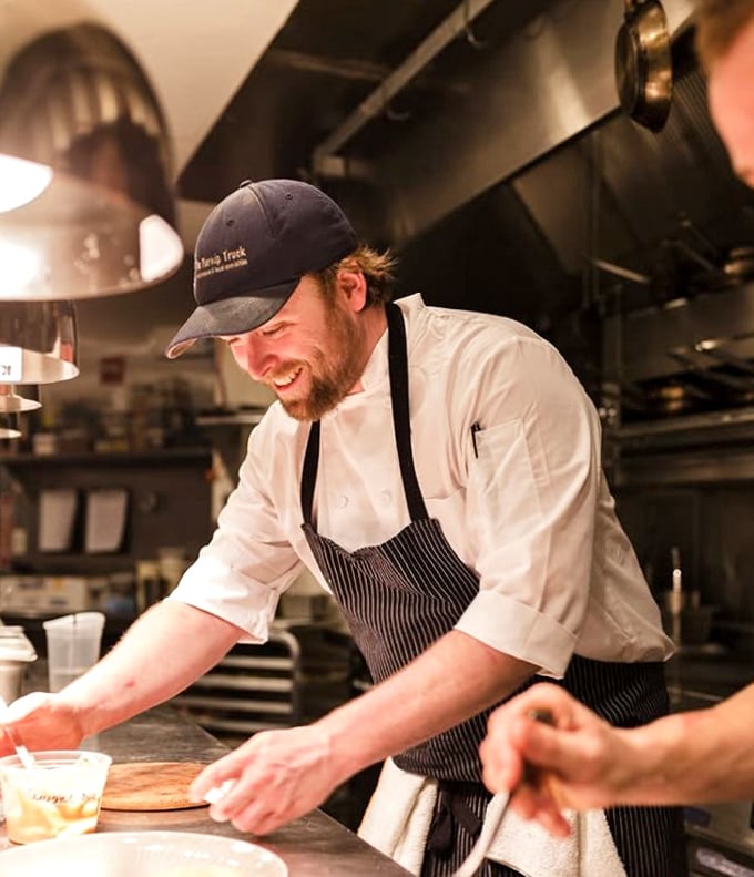 The smile says it all—cooking with joy translates directly to the plate. Happy chefs make happy food.