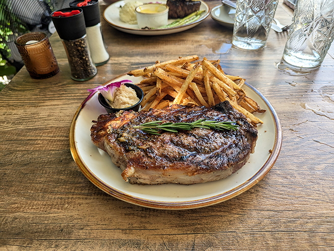 This isn't just a steak—it's a commitment to excellence, complete with a sprig of rosemary standing guard. Those fries look hand-cut and twice-fried, as God intended.