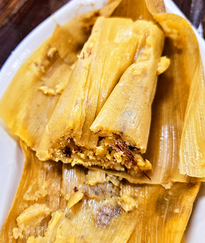 Tamales wrapped like precious gifts, revealing savory treasures within. Unwrap slowly—this moment deserves your full attention.