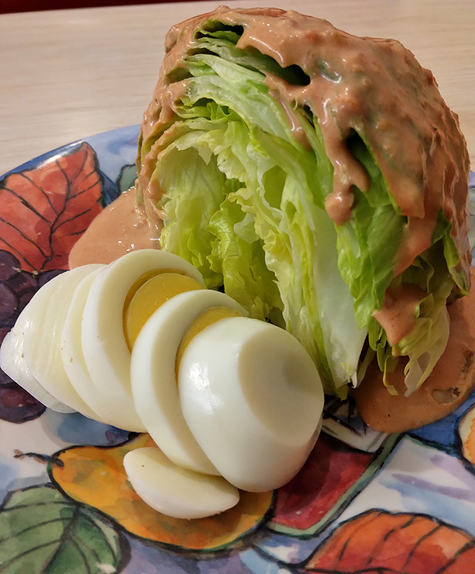 A wedge salad that doesn't skimp on the good stuff. That thousand island dressing cascades like a delicious waterfall over crisp iceberg.