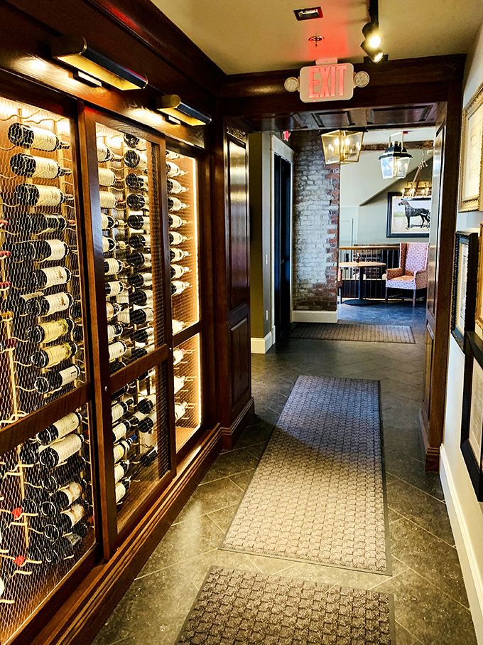 The wine corridor showcases an impressive collection behind glass—liquid treasures waiting to complement your legendary prime rib.