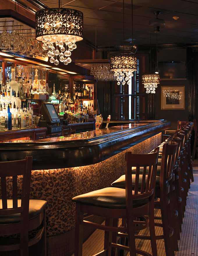 A bar that beckons with the promise of expertly crafted cocktails. Those crystal-draped light fixtures aren't just illumination—they're jewelry.