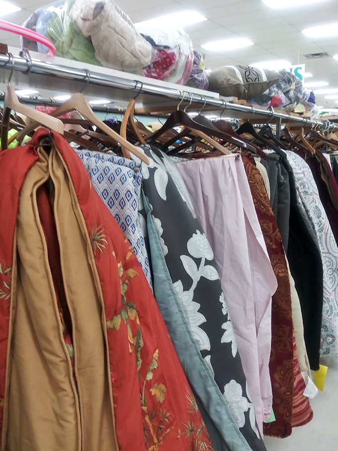 Racks of clothing topped with neatly folded linens—proof that organization can exist even in the most abundant thrift paradise.