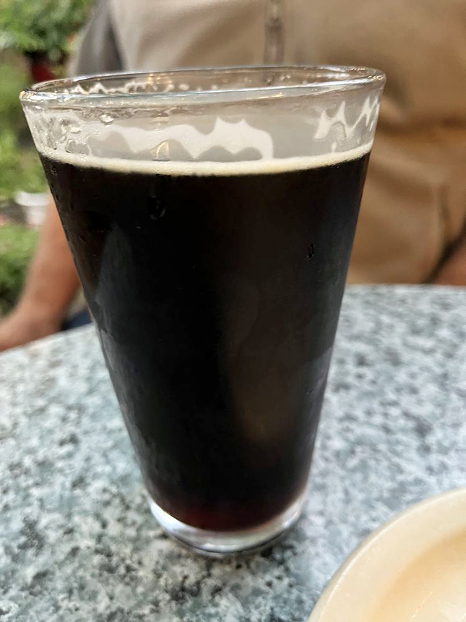 A proper pint of dark beer with that perfect cream top—proof that some traditions are worth preserving for generations.
