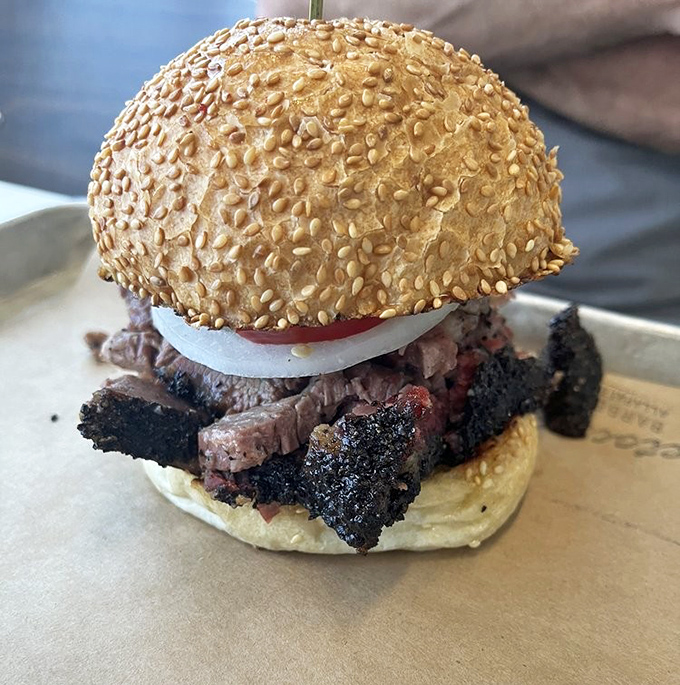 This isn't just a sandwich; it's architecture – a sesame-studded dome supporting the weight of smoky, bark-crusted brisket glory.