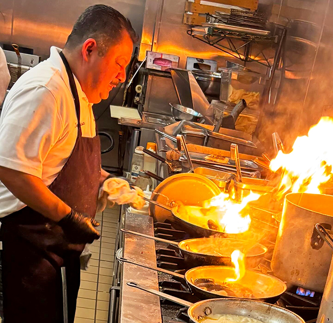Culinary pyrotechnics in action! This chef isn't just cooking—he's performing a flame-kissed symphony that ends with your perfect meal.