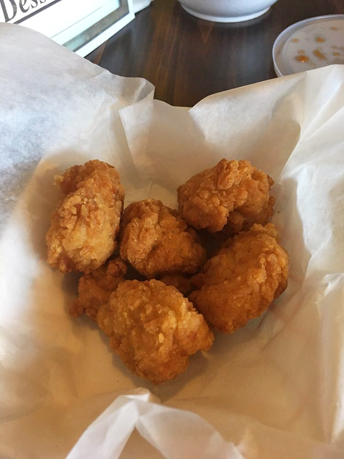 Crispy chicken bites and onion rings nestled in their basket—proof that sometimes the most satisfying meals don't require fancy silverware or white tablecloths.