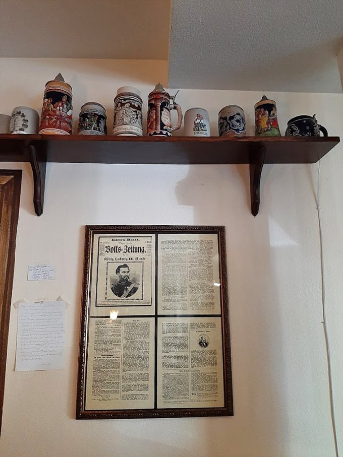 A collection of traditional beer steins stands guard above framed German newspapers—silent storytellers of heritage and craftsmanship.