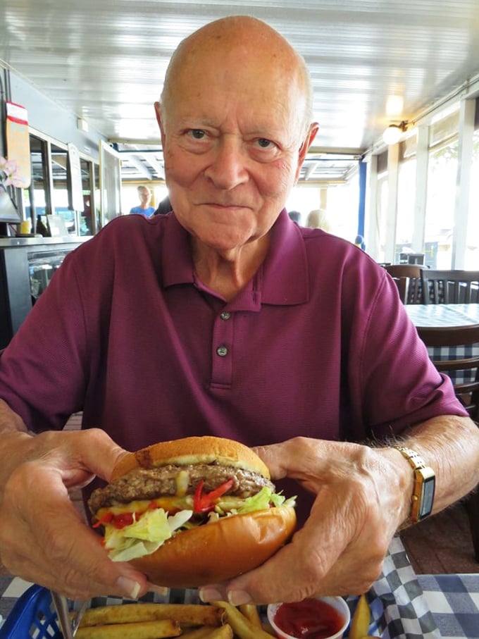 The burger in this patron's hands isn't just lunch—it's the reason smartphones were invented to make friends jealous..
