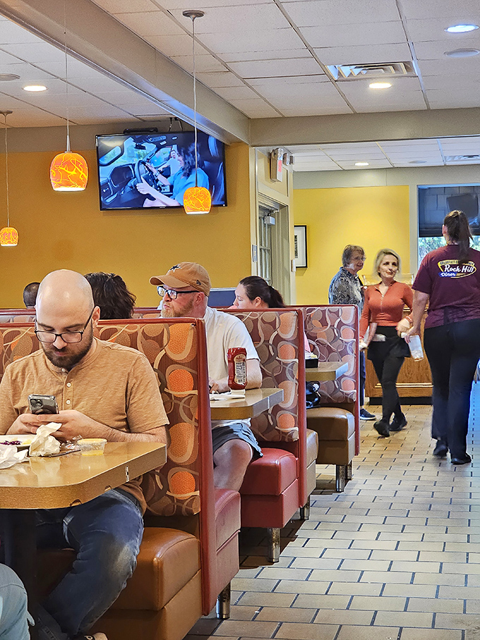 Every booth tells a story – some patrons focused on phones, others on food, all participating in the timeless ritual of the American diner experience.