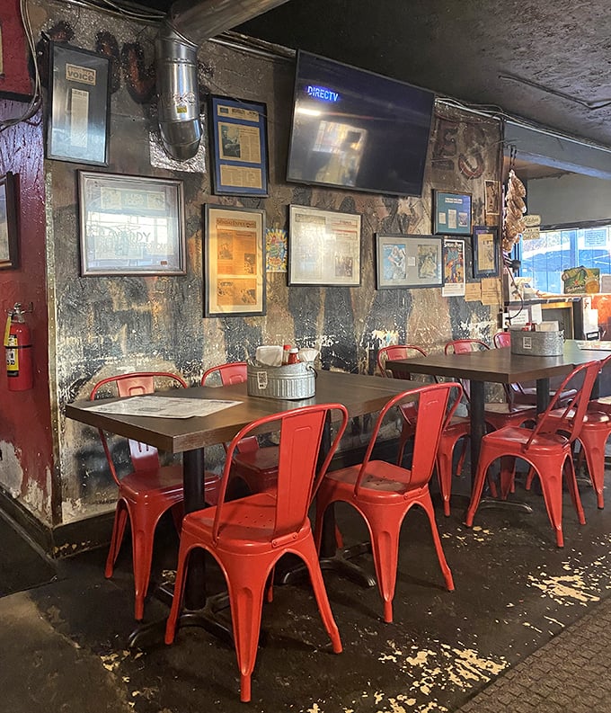 Red metal chairs pop against weathered walls – industrial chic before it was trendy, authentic because it has to be.