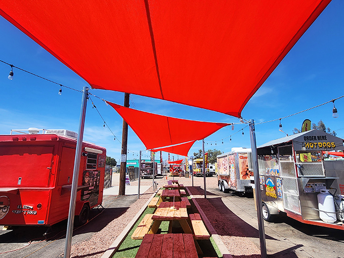 Red canopies provide welcome shade for hungry shoppers. The picnic tables beneath create community dining rooms under the Arizona sky.