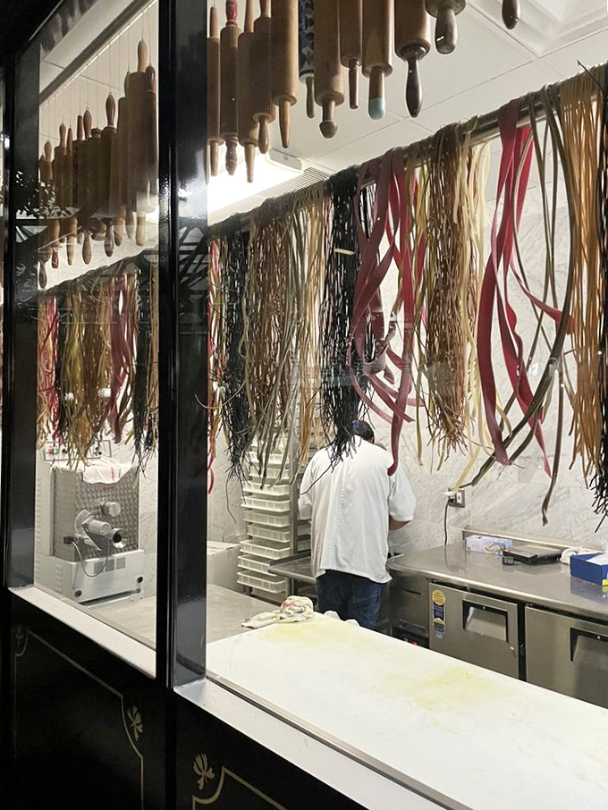 Pasta hanging like edible art—a behind-the-scenes glimpse at the magic before it meets sauce in a delicious Italian love story.