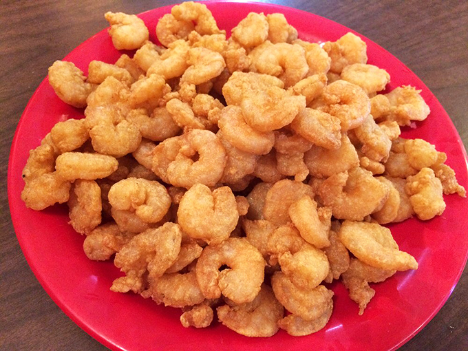 Fried shrimp piled high on a red plate – golden, crispy morsels that disappear faster than you can say "pass the cocktail sauce."