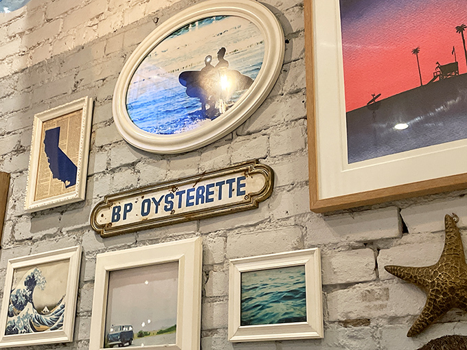 Coastal-themed art adorns white brick walls—a gallery of ocean appreciation that reminds you exactly where your dinner recently resided.