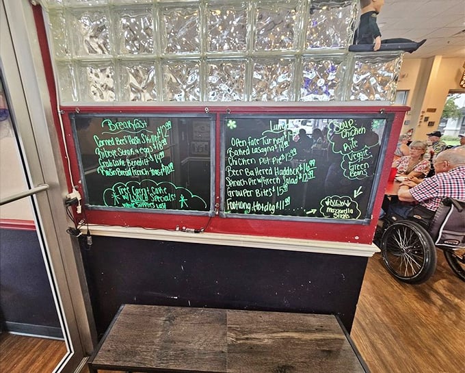 The specials board—where breakfast dreams are born and diet plans go to die, all scrawled in that distinctive diner chalk handwriting.