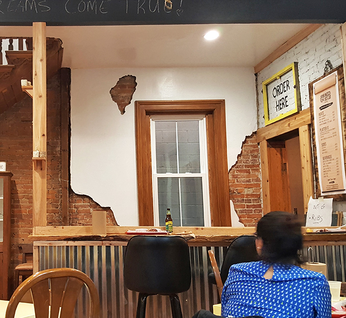 The order counter—where dreams become reality and decisions become dinner. That exposed brick and rustic wood trim screams "authentic" before you take your first bite.