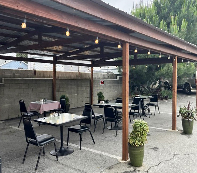 The outdoor seating area offers al fresco dining under simple string lights—California casual meets breakfast brilliance.