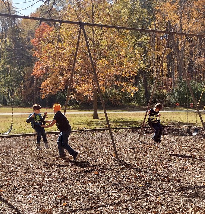 Old-school playground equipment where kids discover the original version of "screen time" involves actual sunshine.