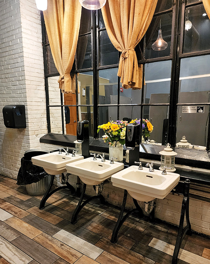 Even the restroom maintains the rustic-chic aesthetic—vintage sinks and burlap curtains prove attention to detail extends beyond the kitchen.