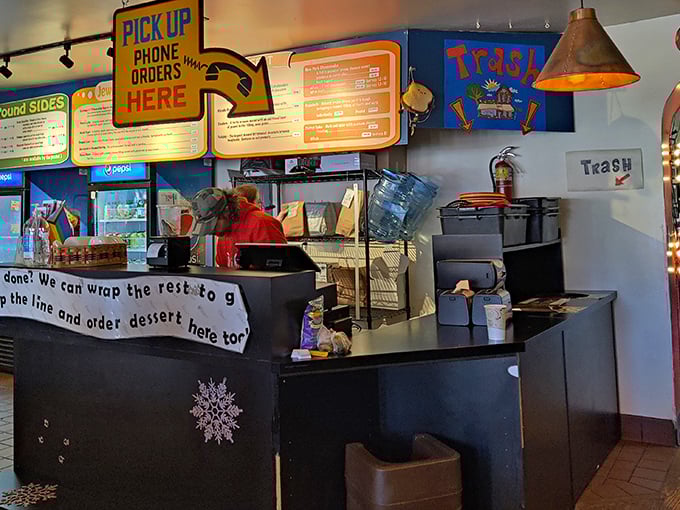 The pickup counter—where anticipation reaches its peak and strangers exchange knowing glances that say, "Yes, we've made excellent life choices today."