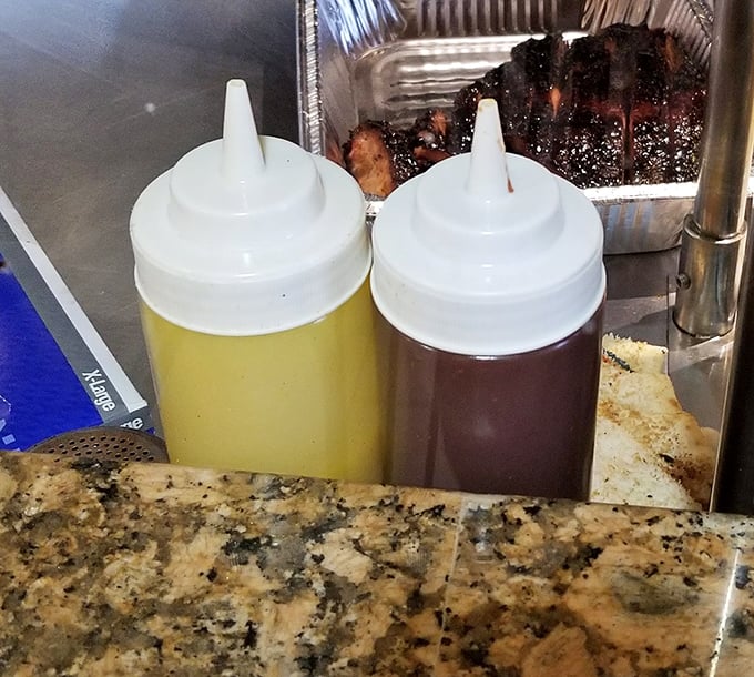 The twin squeeze bottles—barbecue's version of salt and pepper. One sweet, one tangy, both essential for customizing your meat experience.