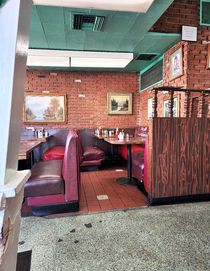 Brick walls, burgundy booths, and landscape paintings create that perfect diner atmosphere where time slows down and conversations flow as freely as the coffee.