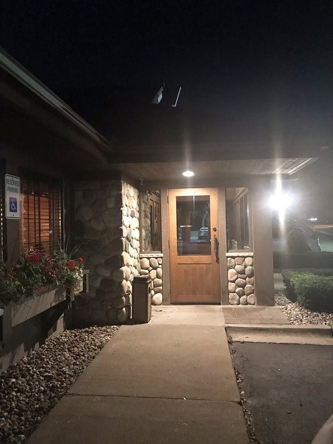 After sunset, the stone entrance glows with welcome—like a lighthouse guiding hungry travelers to safe harbor.