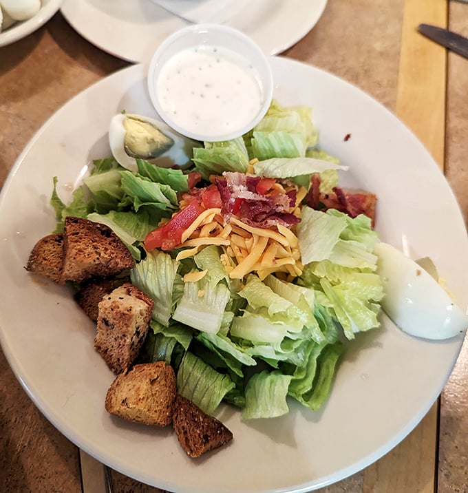 This isn't just a side salad—it's the supporting actor that steals the scene with crisp lettuce, sharp cheddar, and croutons that crunch like autumn leaves.