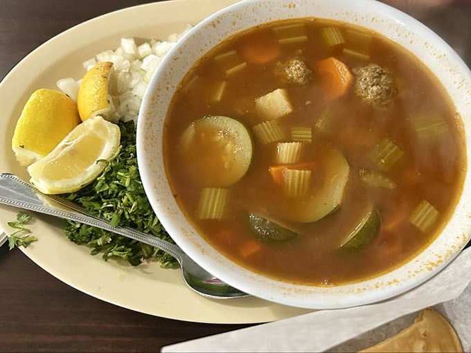 This isn't soup—it's a vegetable swimming pool with meatball lifeguards. The fresh cilantro and lemon are your flavor lifelines.