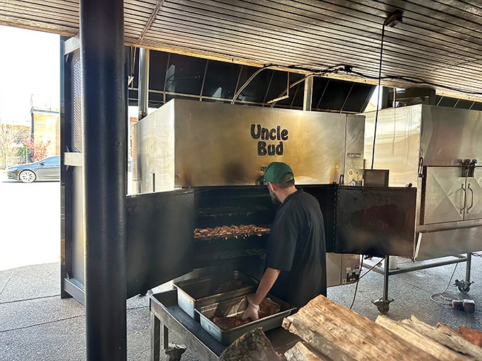 The pitmaster at work, tending to "Uncle Bud"—the smoker that's seen more meat than a butcher's convention. This is where the magic happens.