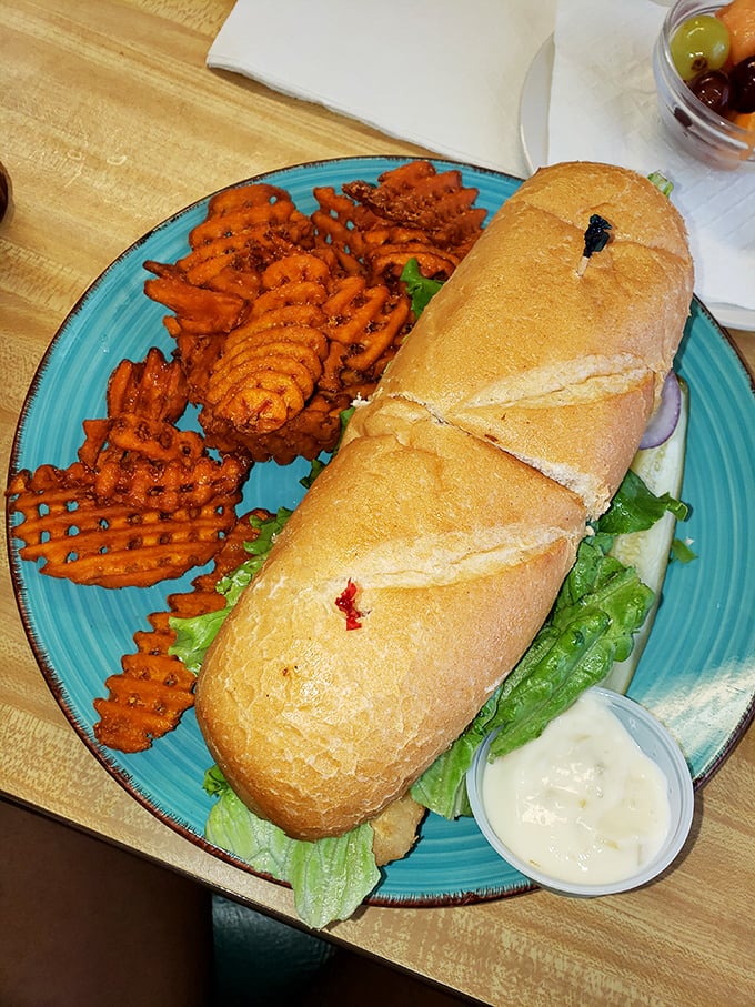 This sub isn't just a sandwich—it's a commitment. Served with waffle fries on that signature turquoise plate, it's a lunchtime showstopper.