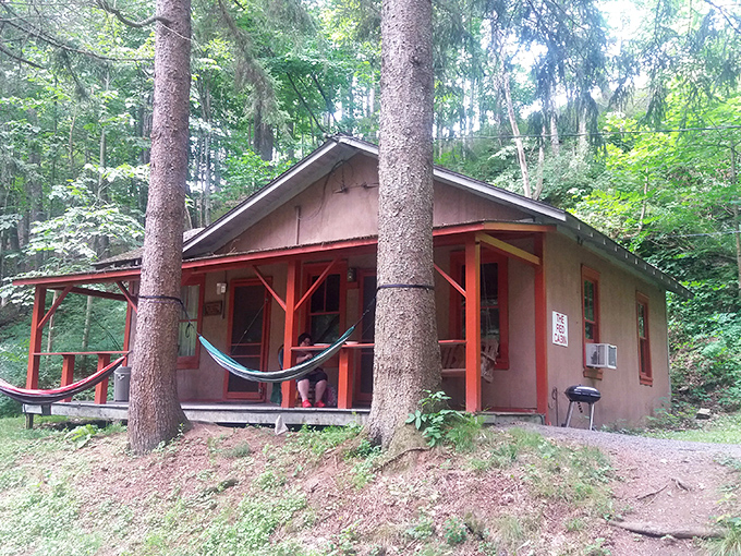 The cozy red cabin offers a perfect spot to unwind after your underground adventure – hammock included for contemplating what lies beneath.