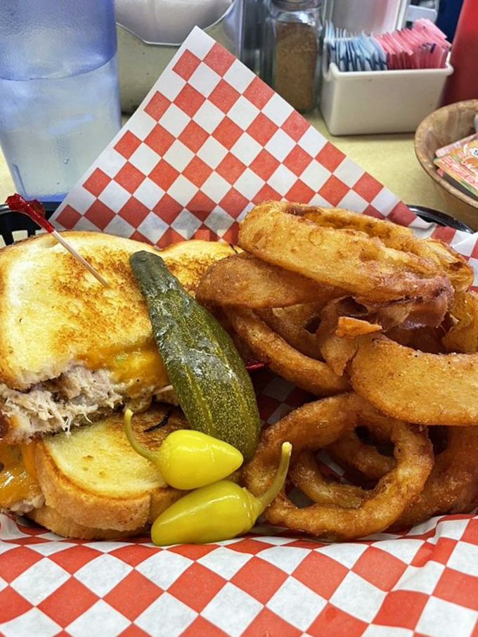 The tuna melt—that perfect marriage of comfort and decadence. With those golden onion rings and a pickle standing guard, it's a lunch that demands a nap afterward.