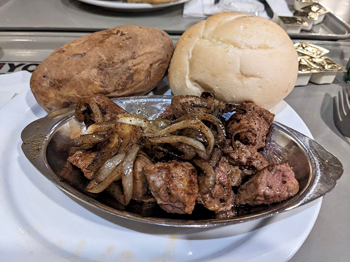 Sirloin tips and caramelized onions perform their savory duet on a silver platter, flanked by a baked potato and roll that know their supporting roles perfectly.
