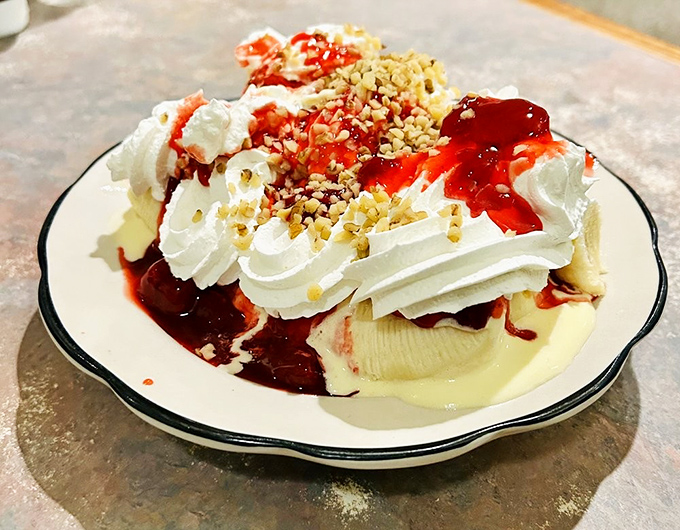 Ice cream, whipped cream, strawberry topping, and nuts create a dessert that's not just eaten but experienced—a carnival of sweetness on a single plate.