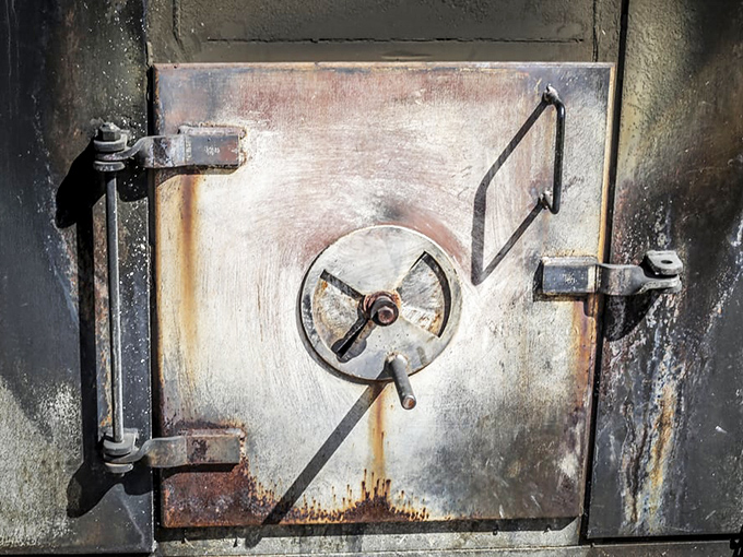 The sacred vault where magic happens—this smoke-seasoned door has seen more perfect briskets than most people will in a lifetime.