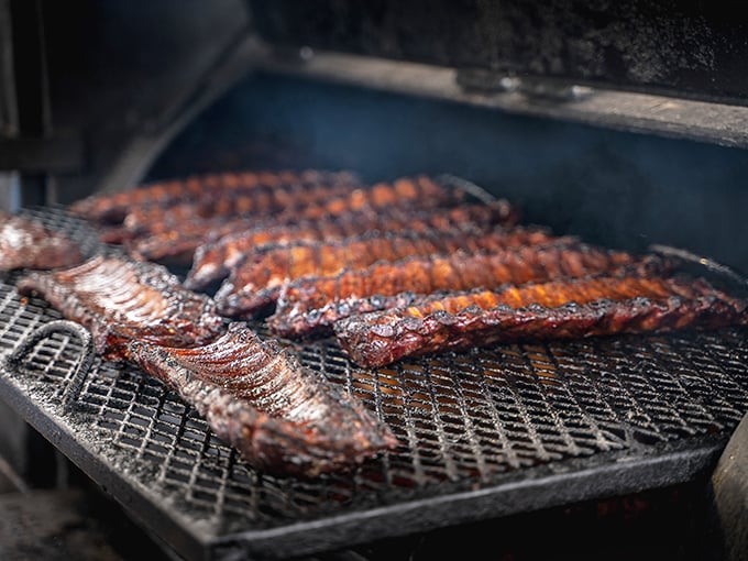 The moment of transformation: when humble meat becomes transcendent barbecue. That smoke isn't just cooking—it's performing alchemy.