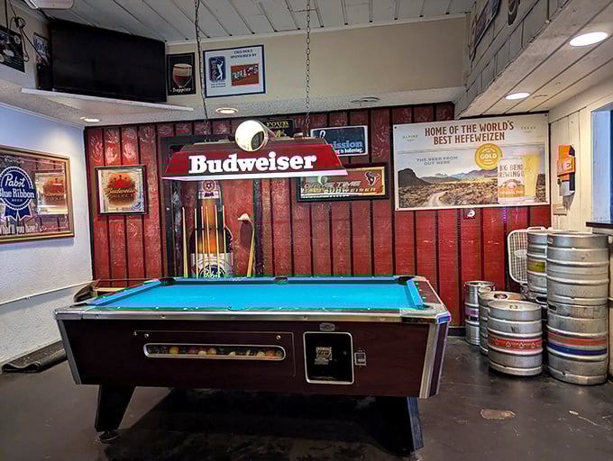 The pool table waits patiently for challengers beneath the watchful gaze of a Budweiser lamp – countless friendly rivalries born on this felt battlefield.
