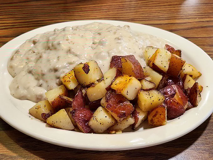 Biscuits and gravy alongside home fries—a breakfast so hearty it could fuel a tractor pull. That pepper-speckled gravy isn't just a topping; it's liquid comfort.