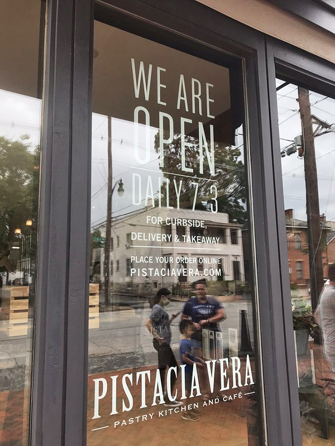 The door announces operating hours like a promise—"We Are Open Daily"—four words that bring comfort in an uncertain world.