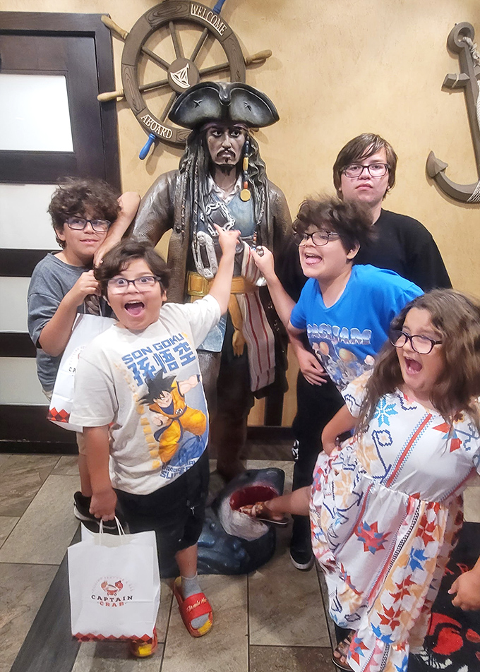 Captain Jack stands guard while young seafood enthusiasts celebrate. Every great restaurant needs a mascot who looks like he might have some stories to tell.