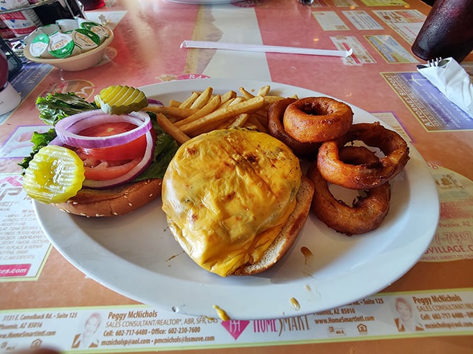A burger that requires jaw exercises beforehand, accompanied by onion rings that achieve the perfect crunch-to-softness ratio every cardiologist fears.