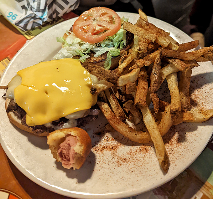 A burger that requires both hands and several napkins – melted cheese cascading down the sides like a yellow waterfall of deliciousness.
