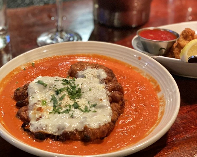 Chicken Parmigiana that doesn't just sit on the plate—it performs, with a supporting cast of bright tomato sauce and melted cheese.