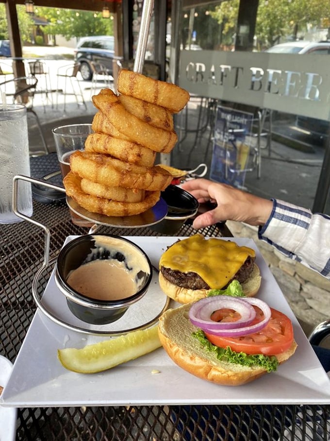 The tower of onion rings threatens to steal the spotlight from the cheeseburger below—a delicious standoff where everyone wins, especially your taste buds.