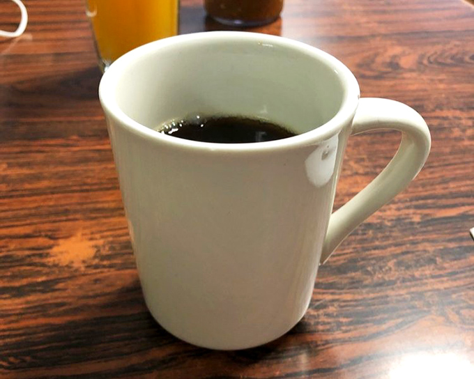 The humble diner coffee mug—holding the life-giving elixir that makes conversation possible before 10 AM. Simple, honest, and exactly what you need.