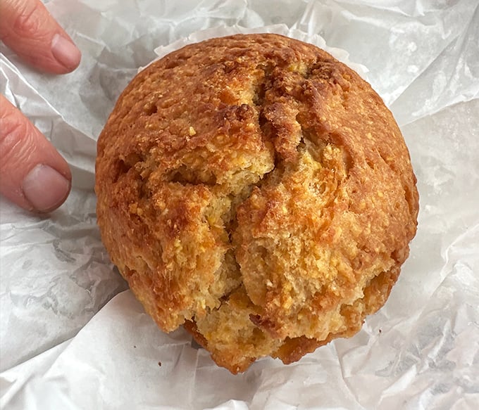 This cornbread muffin has the perfect crack on top—nature's way of telling you it's done right. Golden, crumbly perfection waiting for your first bite.