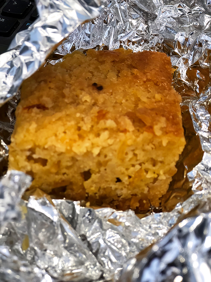 Cornbread wrapped in foil like the precious gift it is—golden, crumbly, and ready to complete your barbecue experience with buttery perfection.