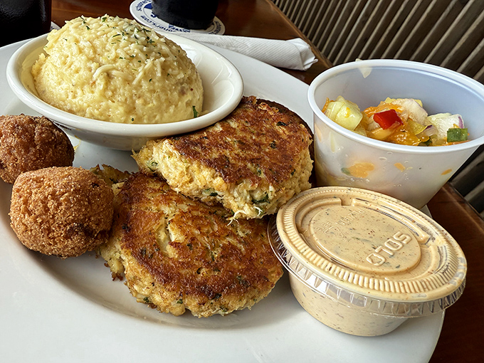 Crab cakes and hushpuppies – the dynamic duo of coastal comfort food – arrive golden-brown and ready to transport you to seafood nirvana. 